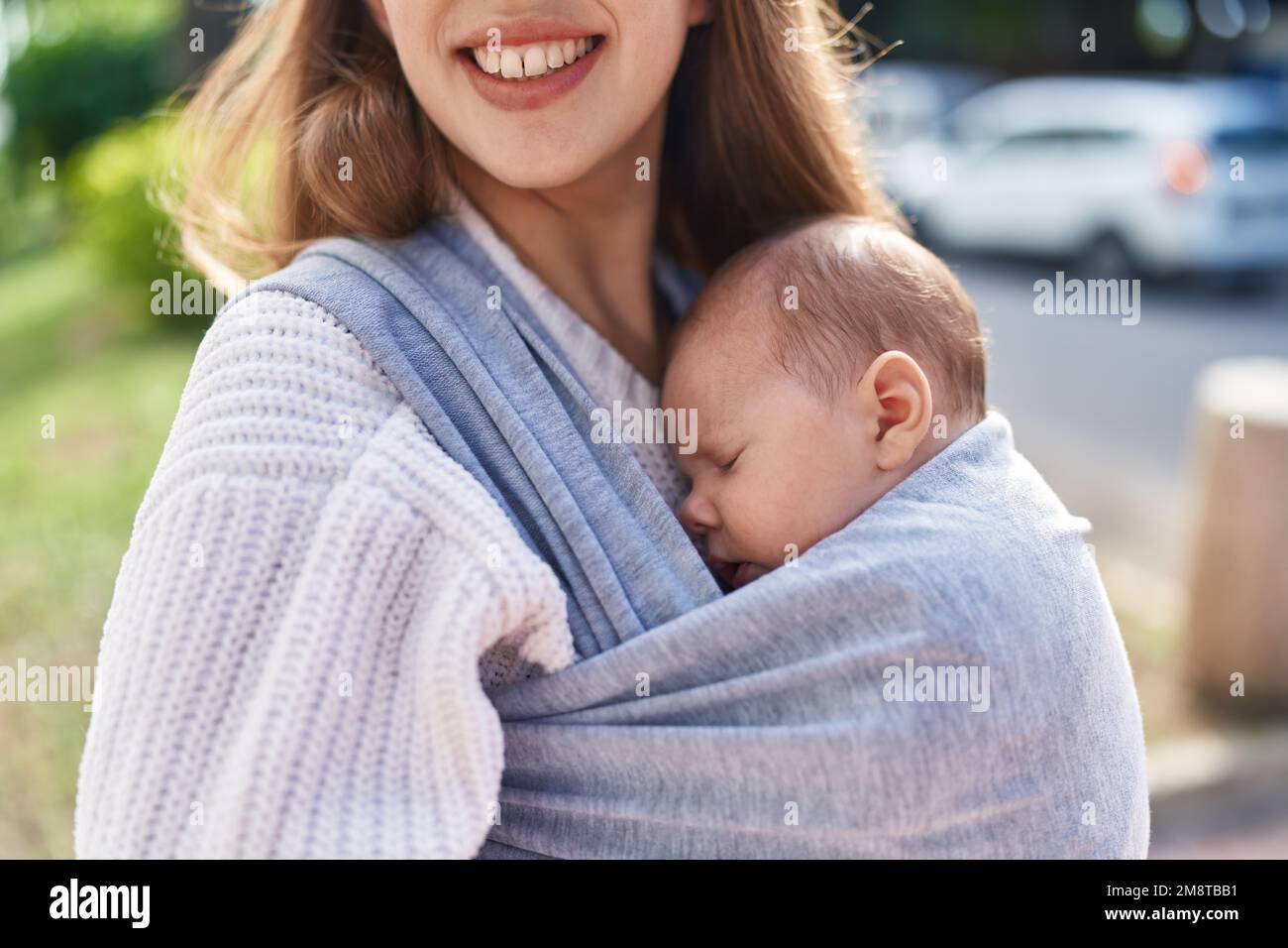 Mother and son sleeping baby standing at street Stock Photo - Alamy