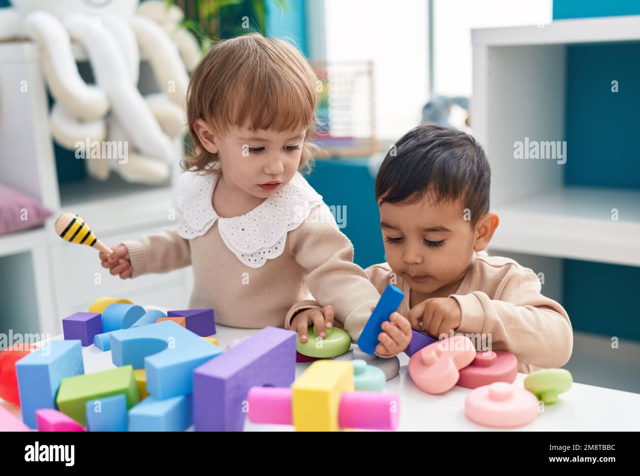 Two kids playing with construction blocks standing at kindergarten ...
