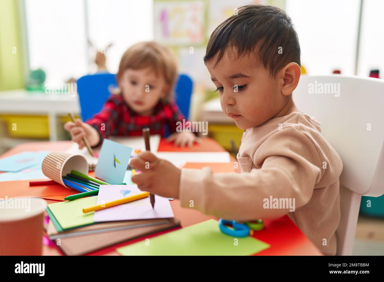 Two kids preschool students sitting on table drawing on paper at ...