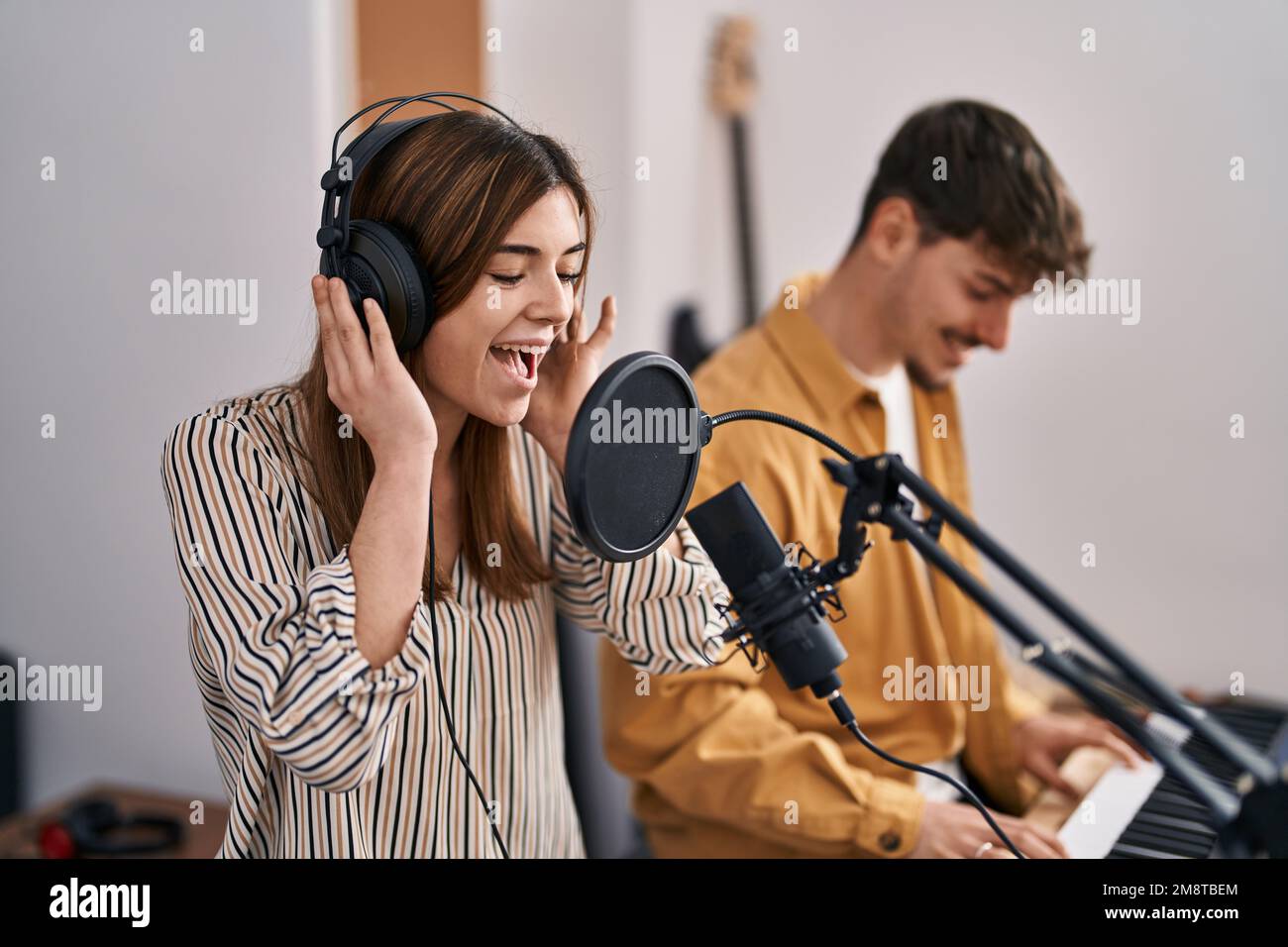 Mand and woman musicians singing song playing piano keyboard at music ...