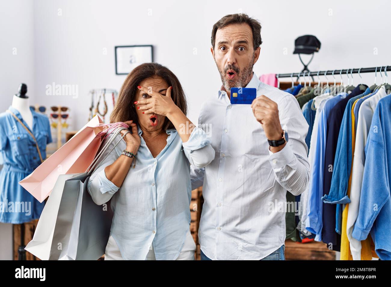 Hispanic middle age couple holding shopping bags and credit card ...