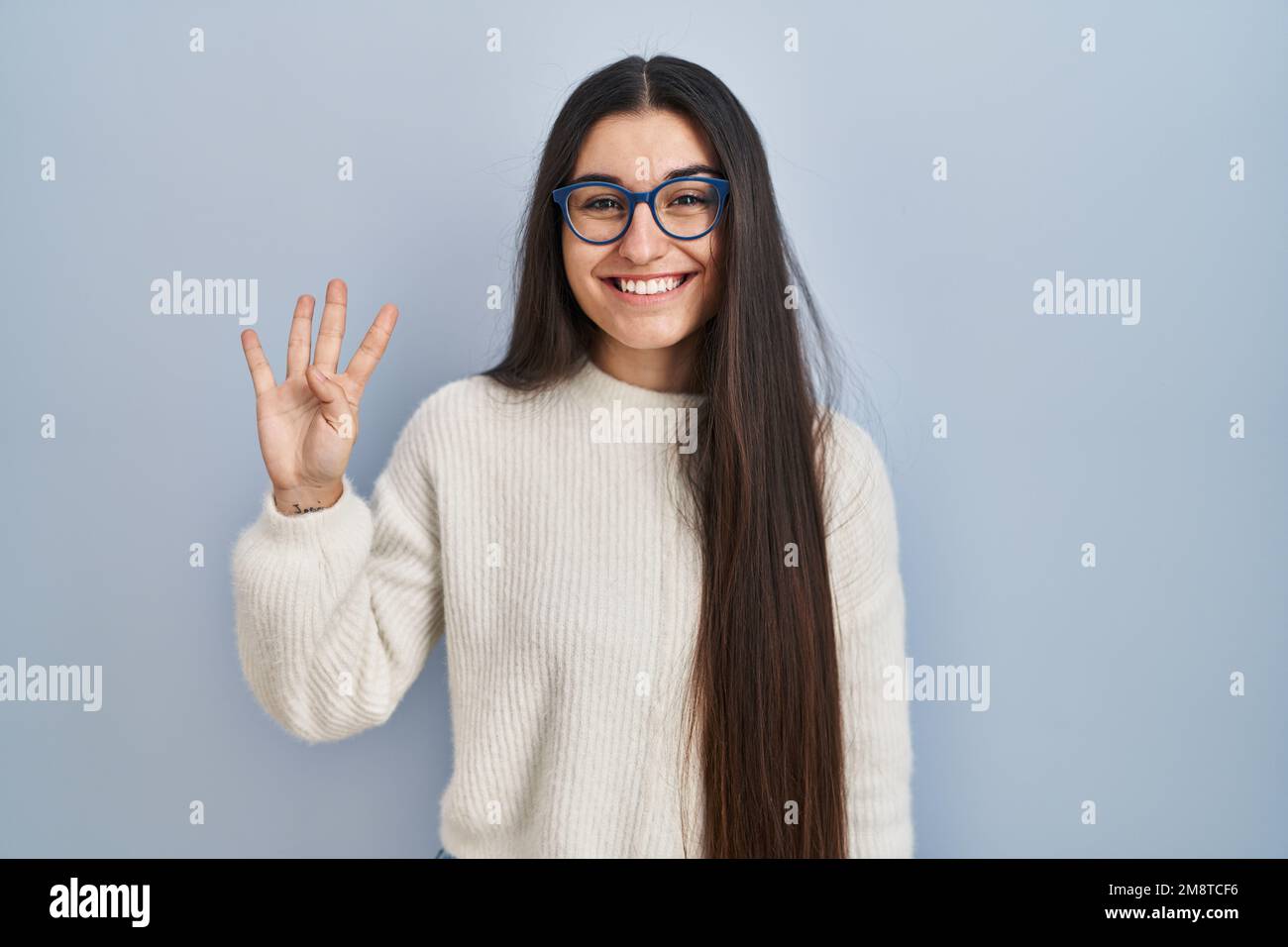 Young hispanic woman wearing casual sweater over blue background ...