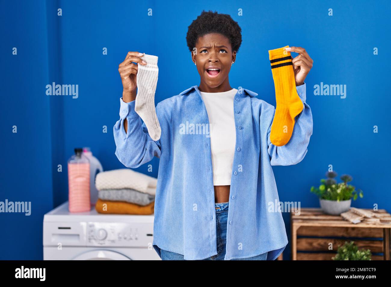 African american woman holding clean andy dirty socks angry and mad ...