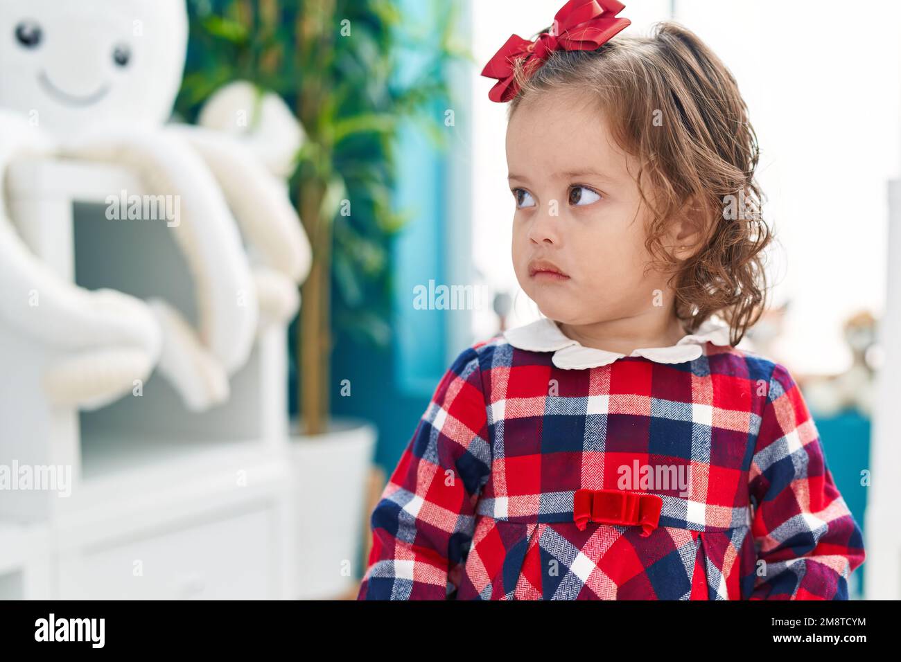 Adorable blonde toddler standing with serious expression at ...