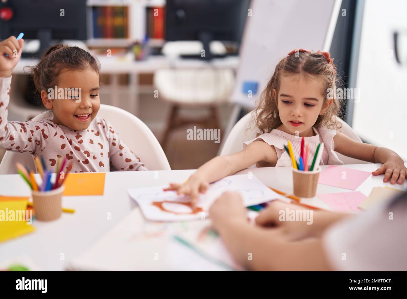 Two kids preschool students having lesson with teacher at classroom ...