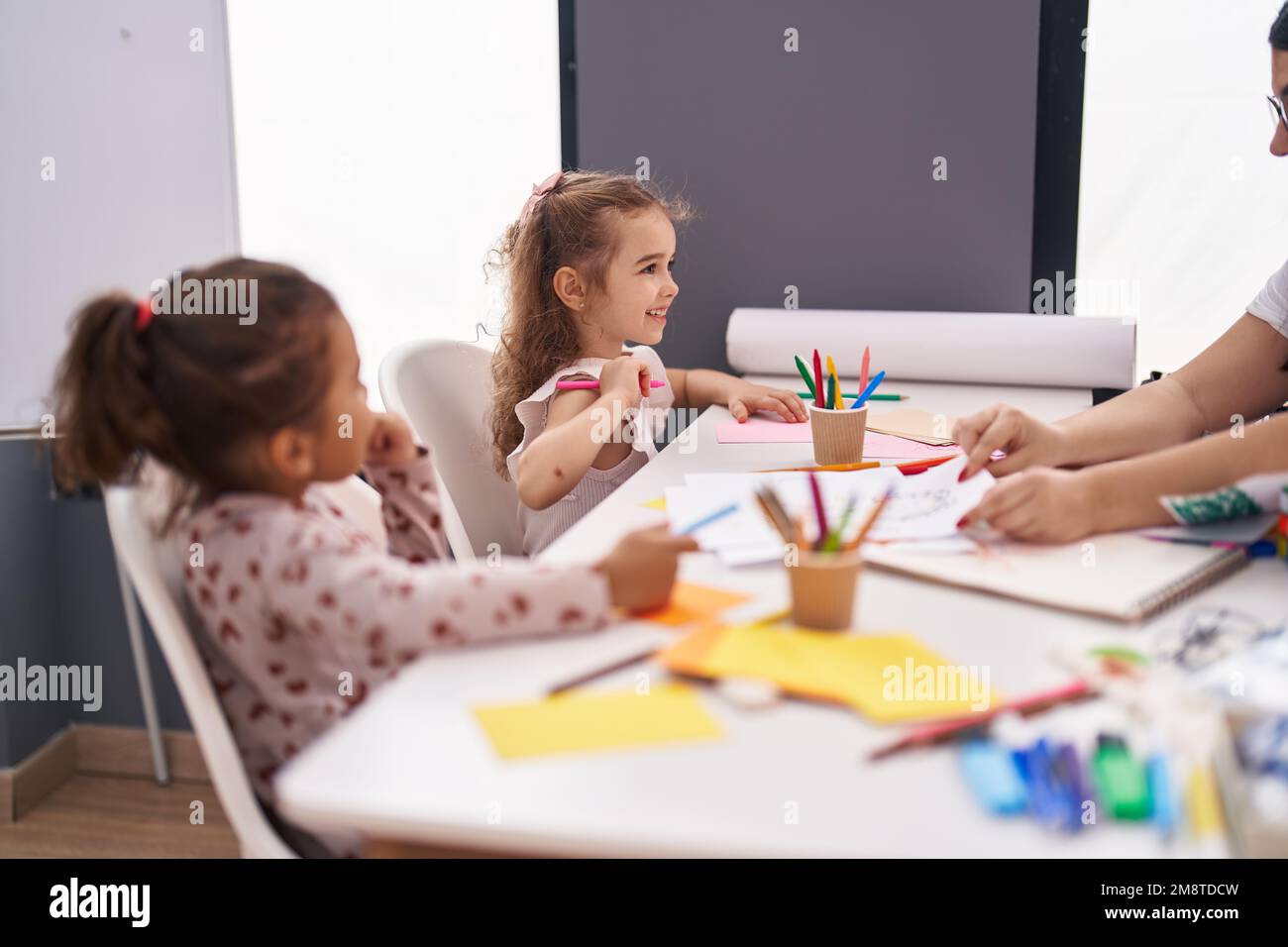 Two kids preschool students sitting on table drawing on paper at ...