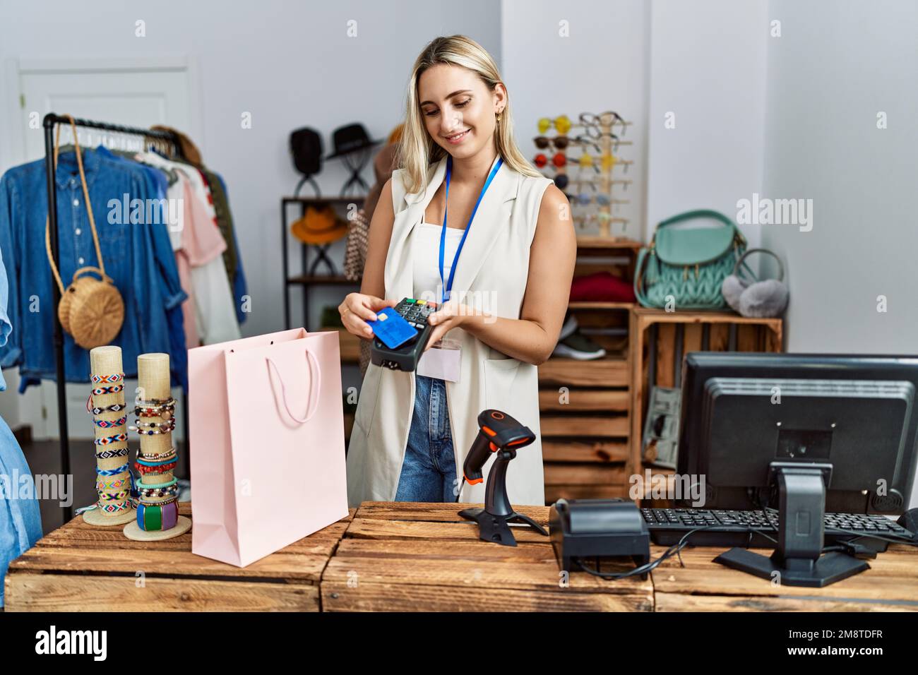 Young blonde woman smiling confident paying with credit card at ...