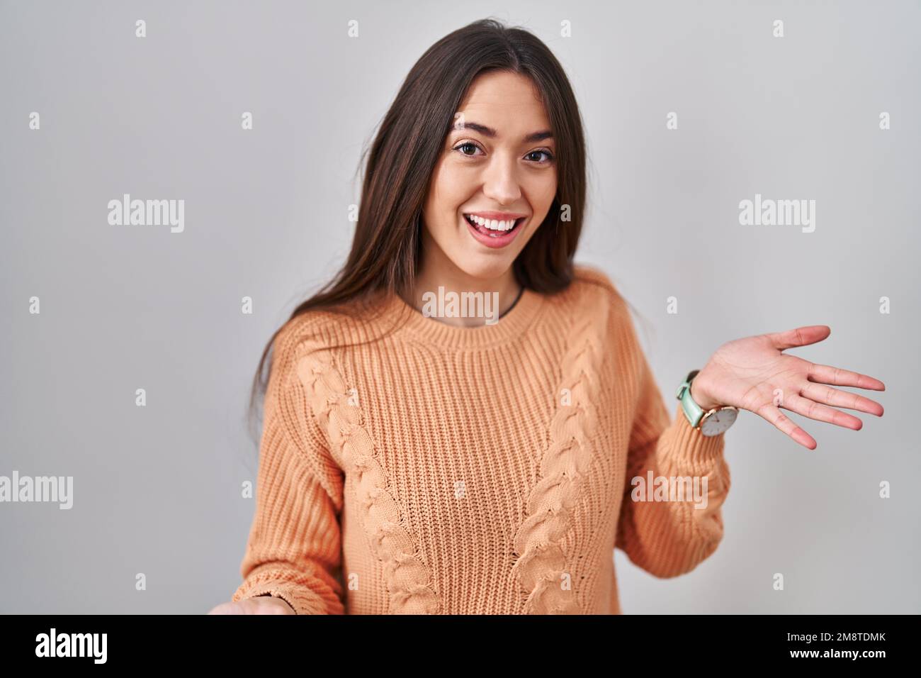 Young brunette woman standing over white background smiling cheerful ...