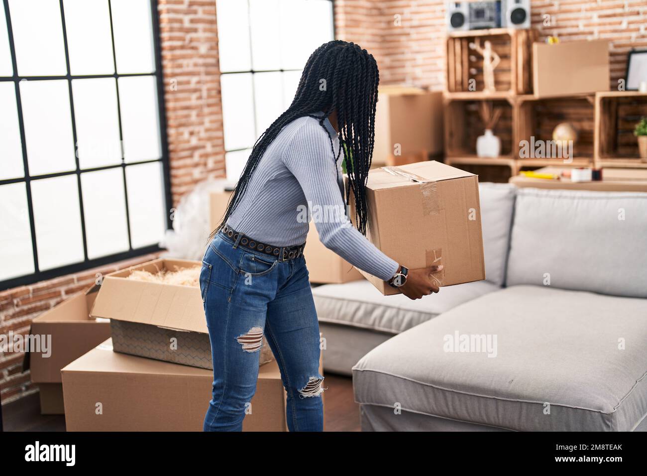 African american woman holding fragile package at new home Stock Photo ...