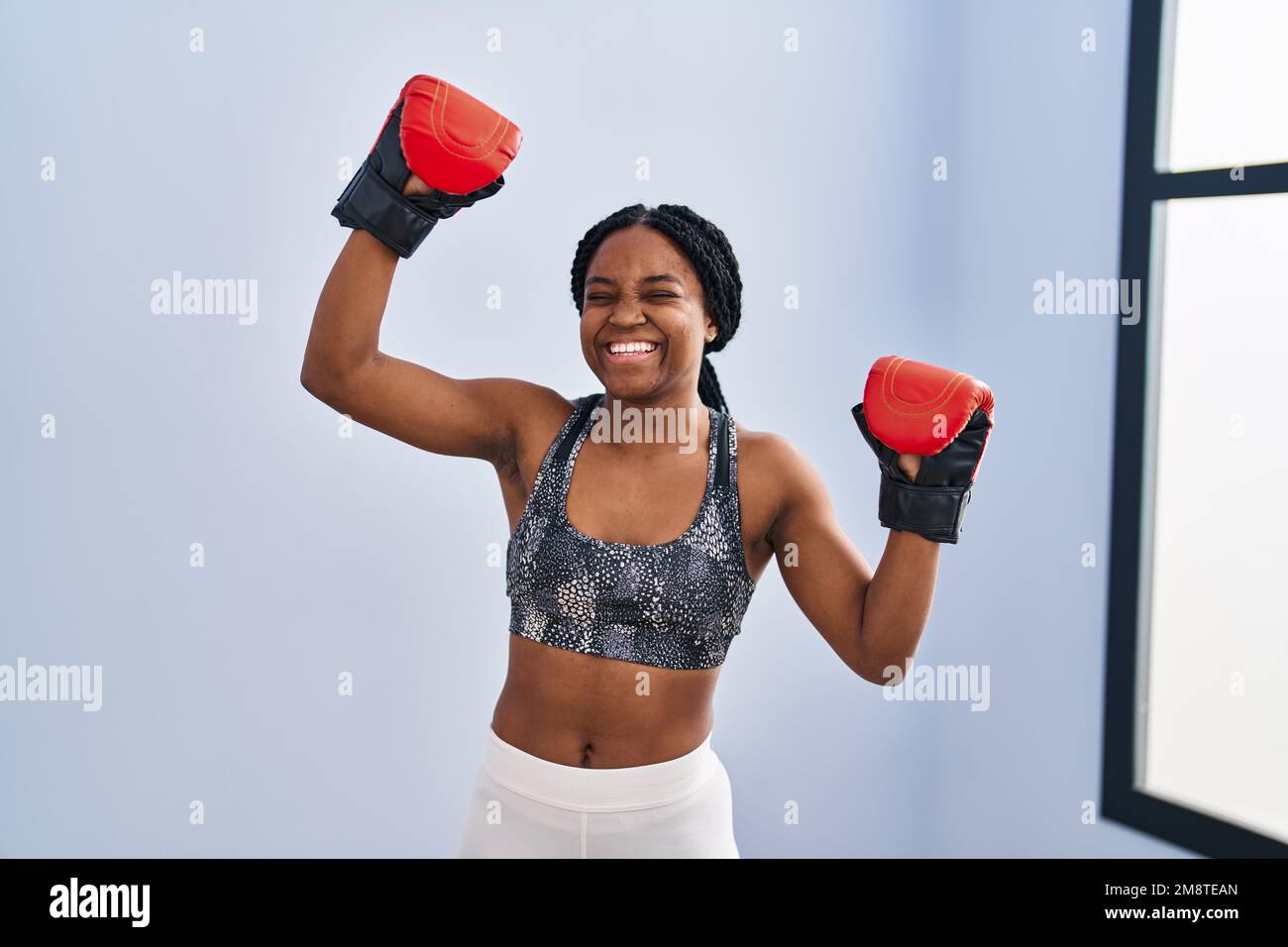African american woman smiling confident wearing boxing gloves at sport ...