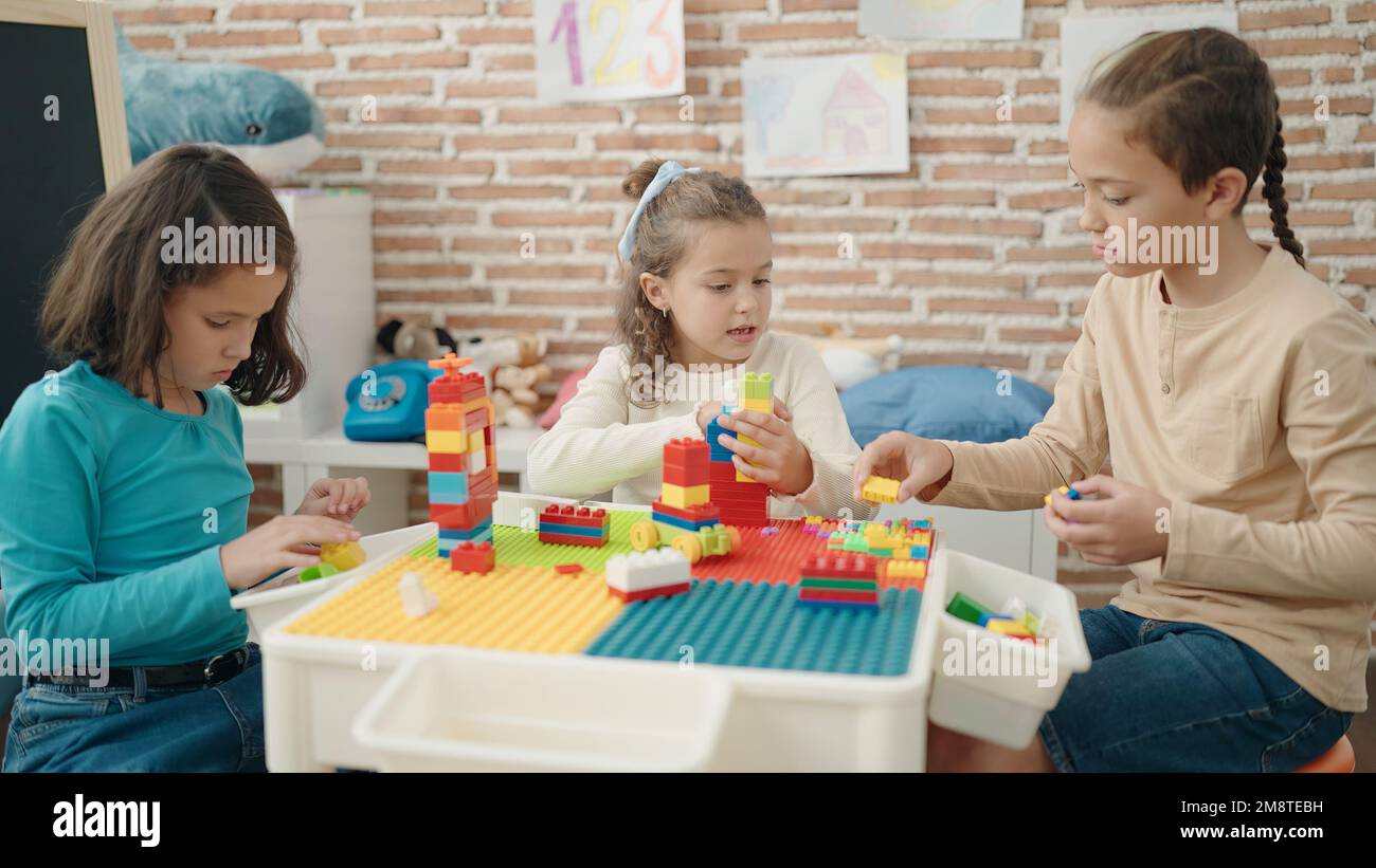 Group of kids playing with construction blocks sitting on table at ...