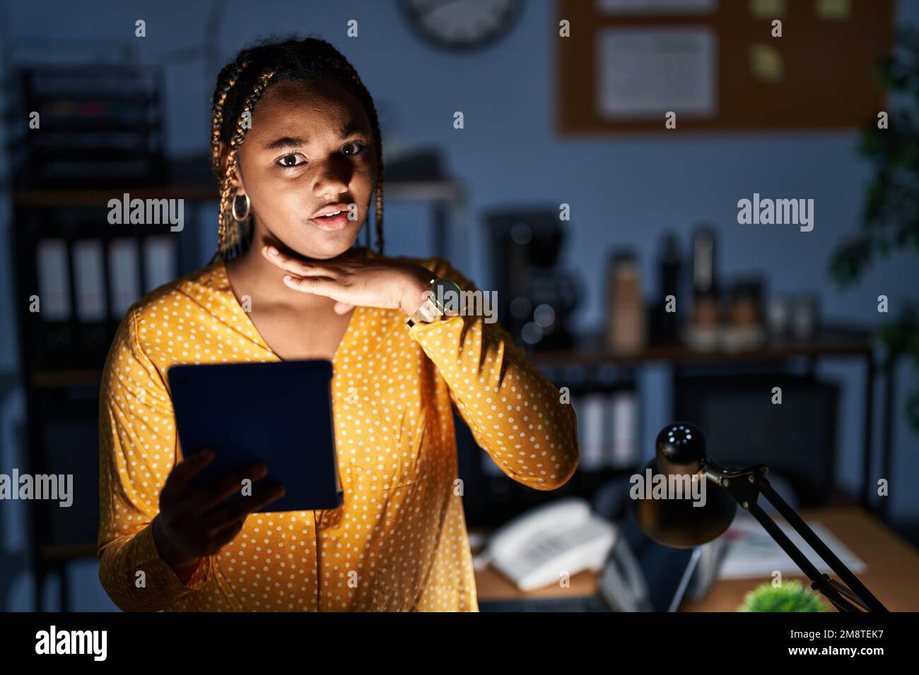 African american woman with braids working at the office at night with ...