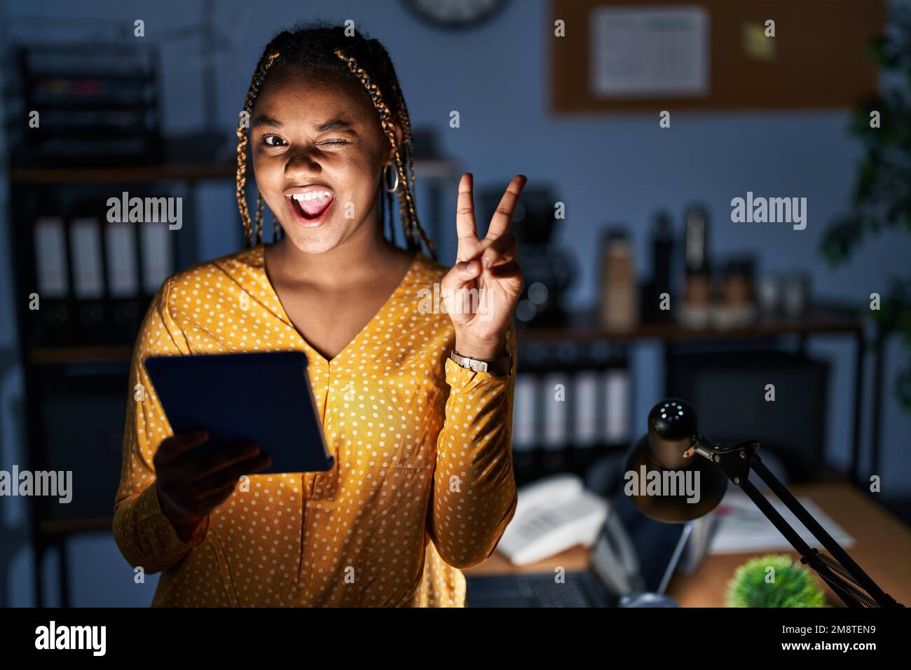 African american woman with braids working at the office at night with ...