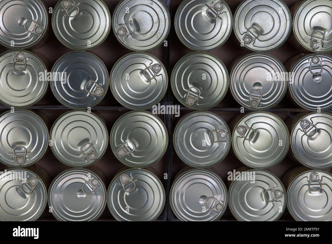 Food behind sheet metal. Lined up tin cans with pull-off lids viewed ...