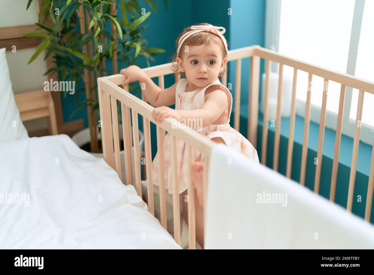 Adorable caucasian girl standing on cradle at bedroom Stock Photo - Alamy
