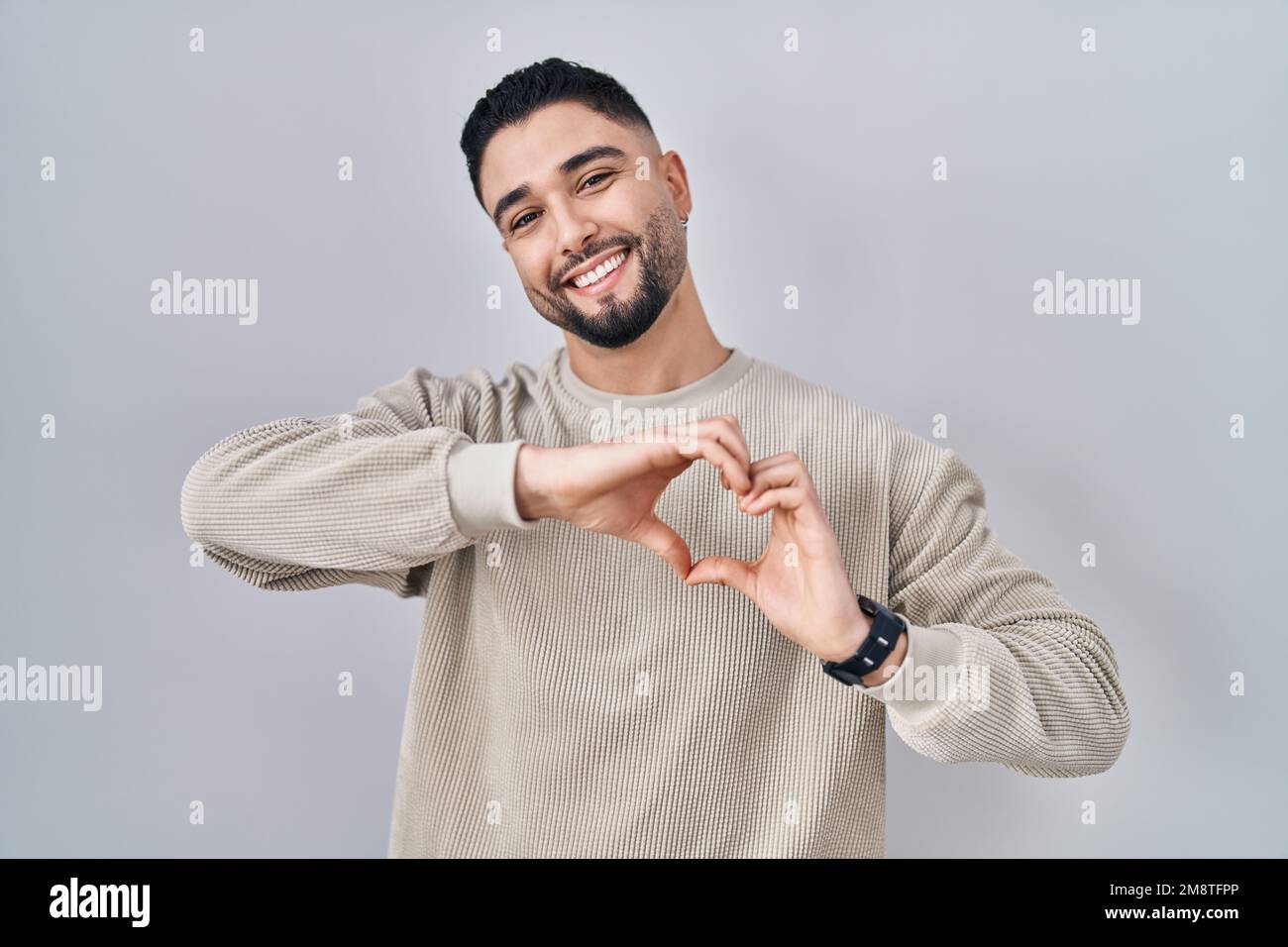 Young handsome man standing over isolated background smiling in love ...