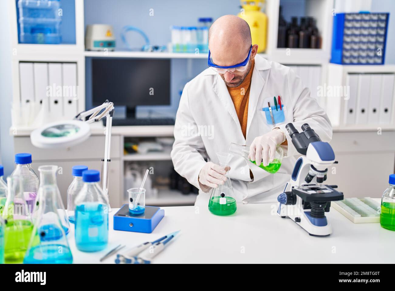 Young man scientist measuring liquid at laboratory Stock Photo - Alamy