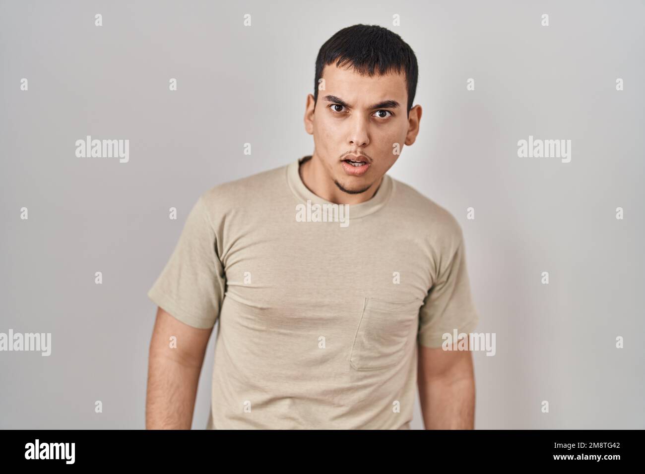 Young arab man wearing casual t shirt in shock face, looking skeptical ...