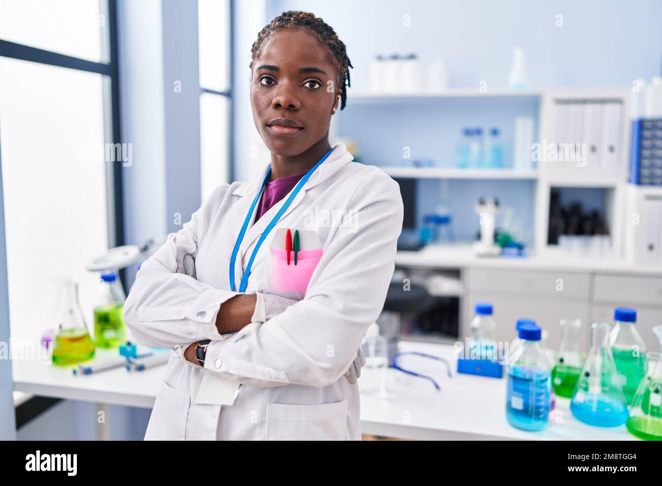 African american woman wearing scientist uniform standing with arms ...