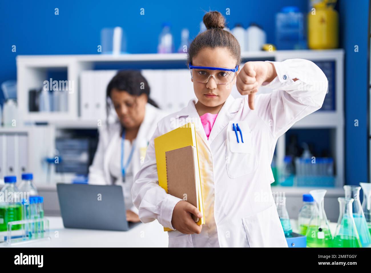 Mother and young daughter working at scientist laboratory with angry ...