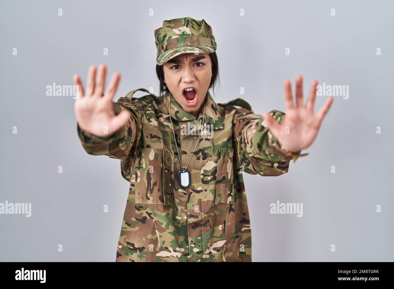 Young south asian woman wearing camouflage army uniform doing stop ...