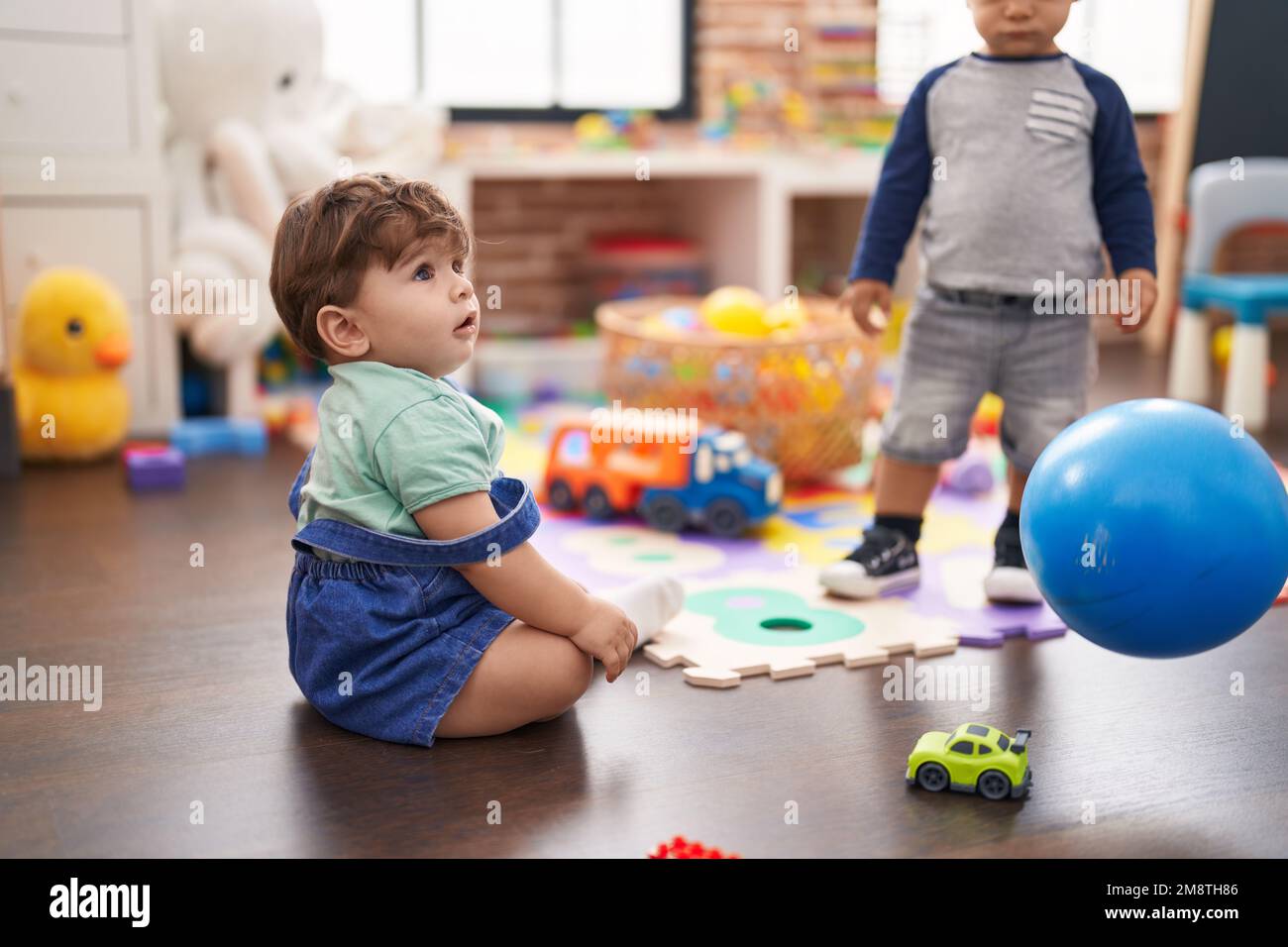 Two kids playing with ball standing at kindergarten Stock Photo - Alamy