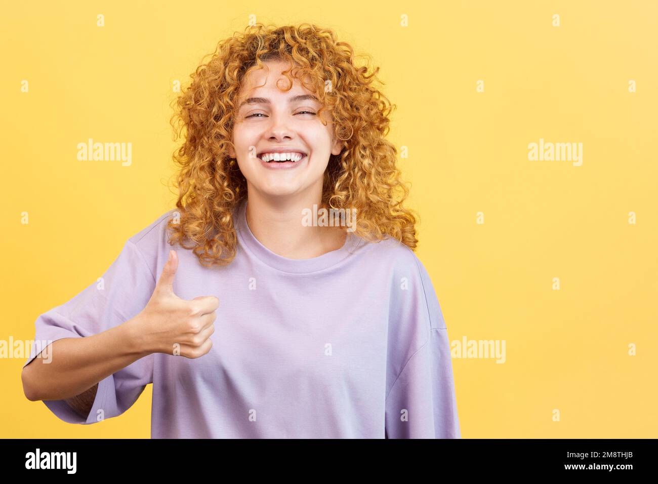Woman with curly hair gesturing agreement raising the thumb Stock Photo ...