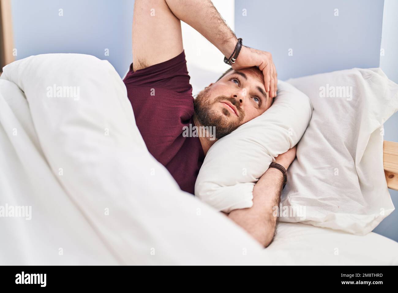 Young hispanic man suffering insomnia lying on bed at bedroom Stock ...