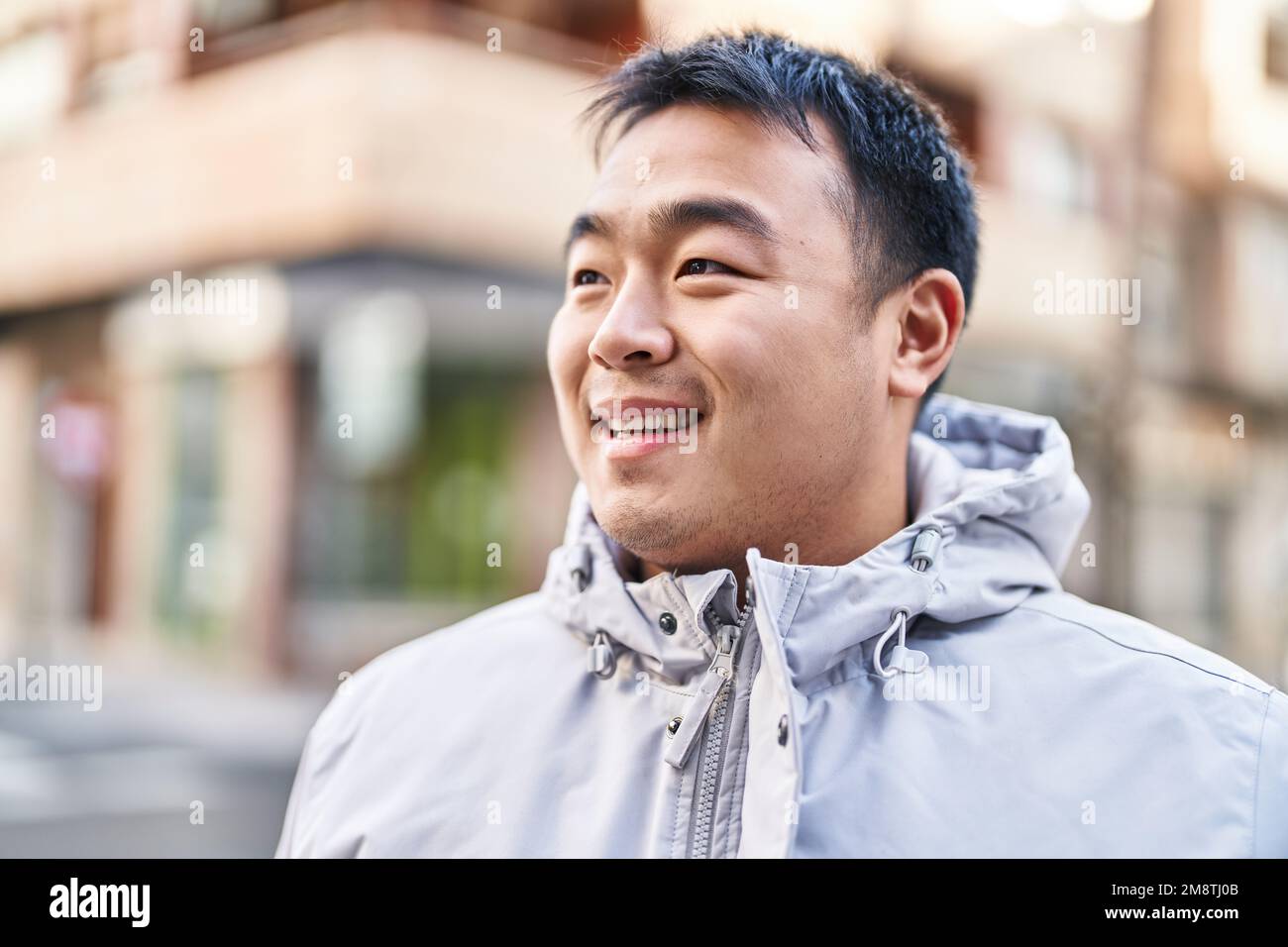 Young chinese man smiling confident standing at street Stock Photo - Alamy