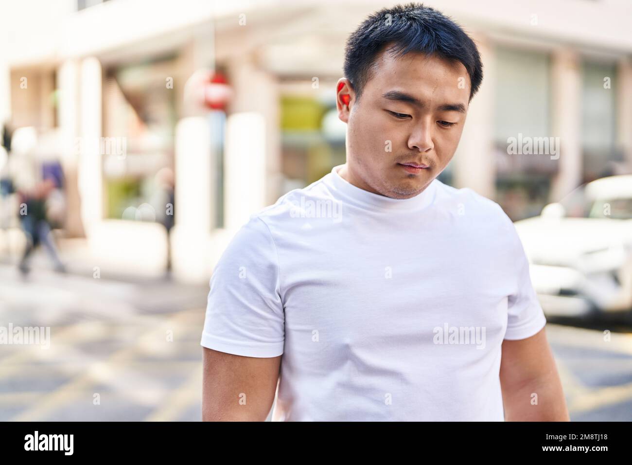 Young chinese man standing with relaxed expression at street Stock ...