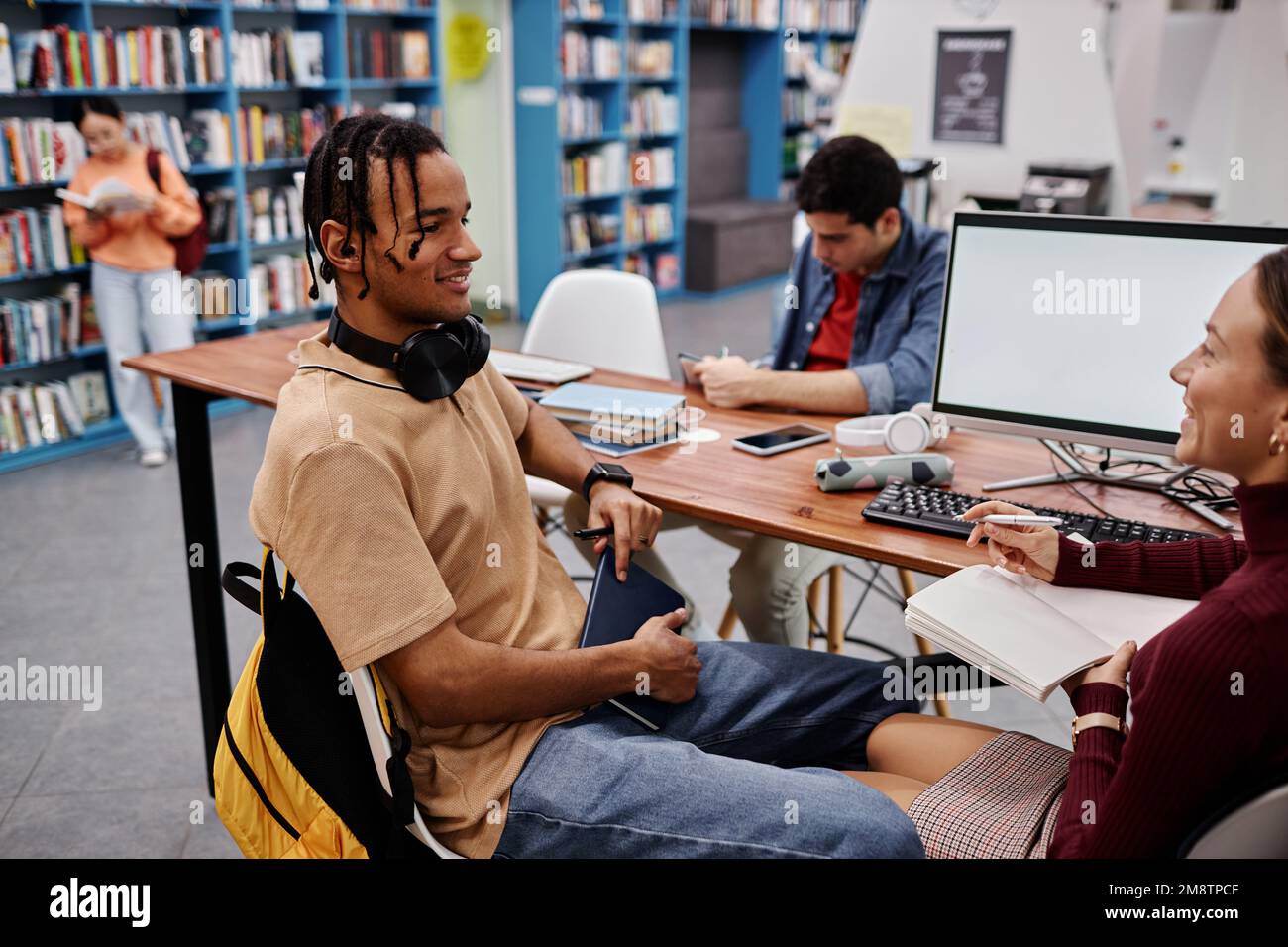 Side view portrait of black teenage boy talking to friend in colorful ...
