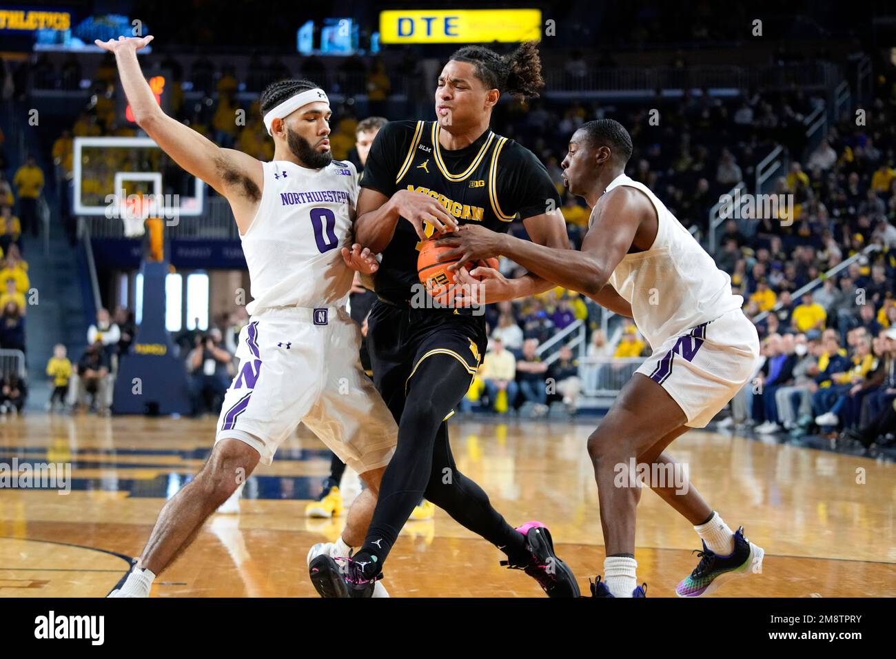 Michigan guard Jett Howard (13) drives between Northwestern guard Boo ...