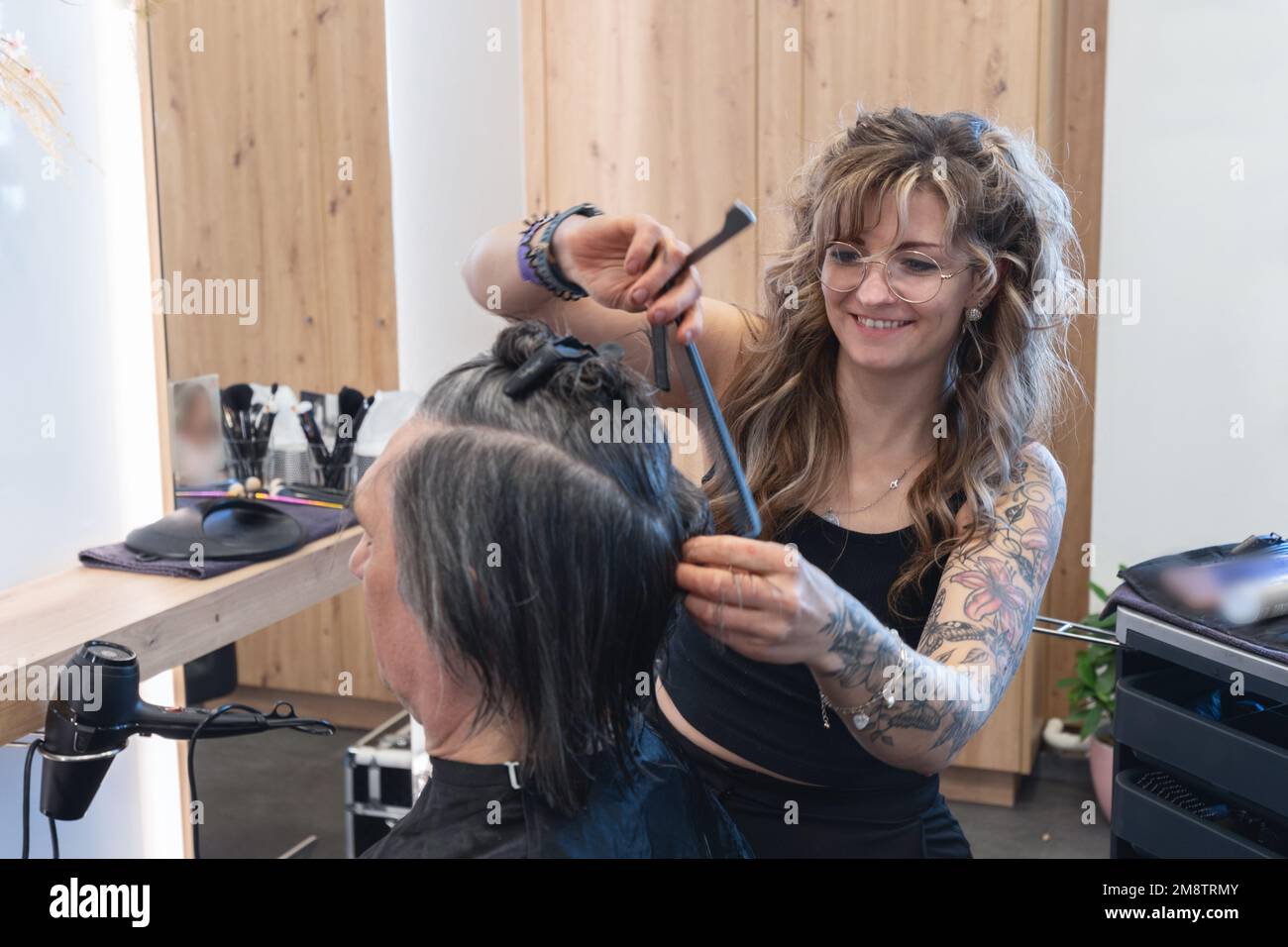 cute barber cuts a middle-aged man's haircut Stock Photo - Alamy