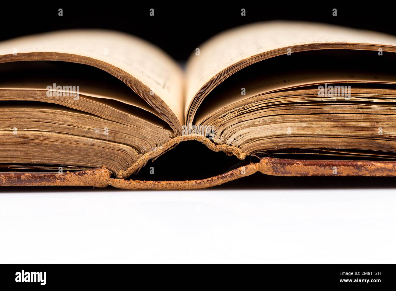 ancient book shot on black background. The book is in bad condition ...