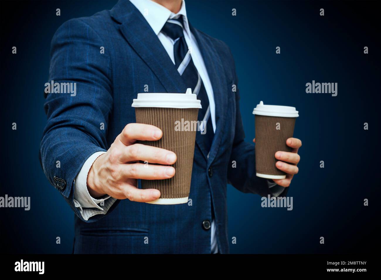 Businessman offering coffee in paper cup. Businessman offers a cup of ...