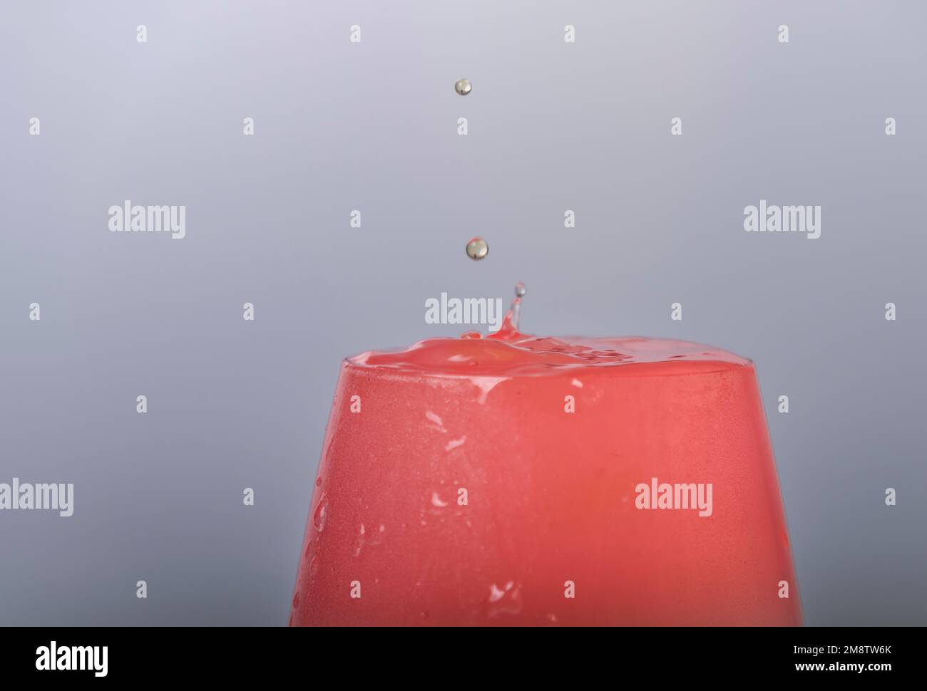 Color drops fall to wine glass with color light liquid Stock Photo - Alamy