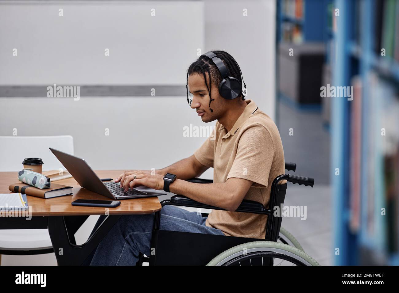 Side view portrait of black teenage boy with disability studying in ...