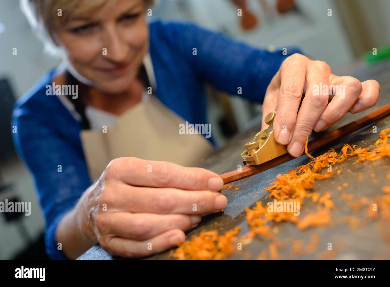 artisan woman shaving wooden baton with hand jack plane Stock Photo - Alamy