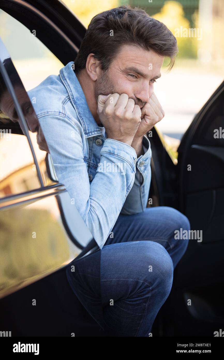 portrait of a young sad man sitting in car Stock Photo - Alamy