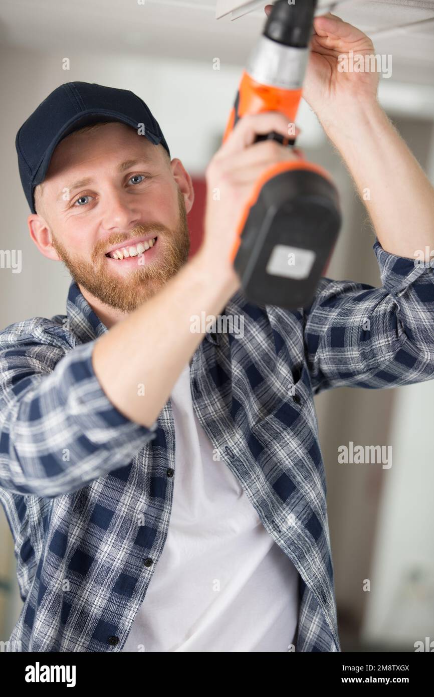 young man fixing drywall suspended ceiling Stock Photo - Alamy