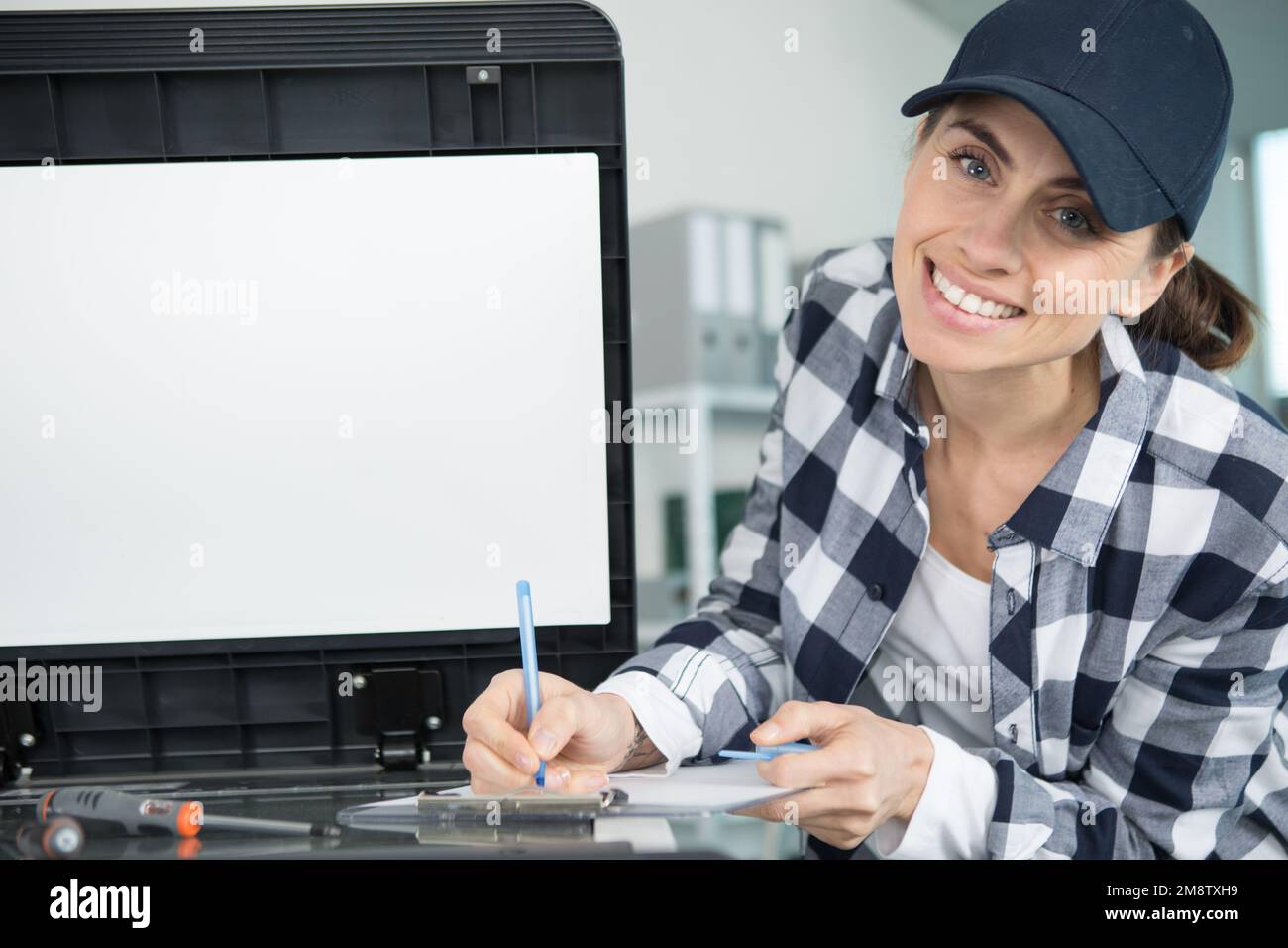 female technician writing up a report Stock Photo - Alamy