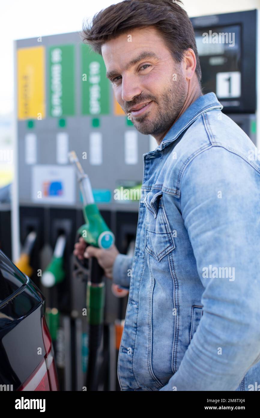 young man refuelling a car at a petrol station Stock Photo - Alamy