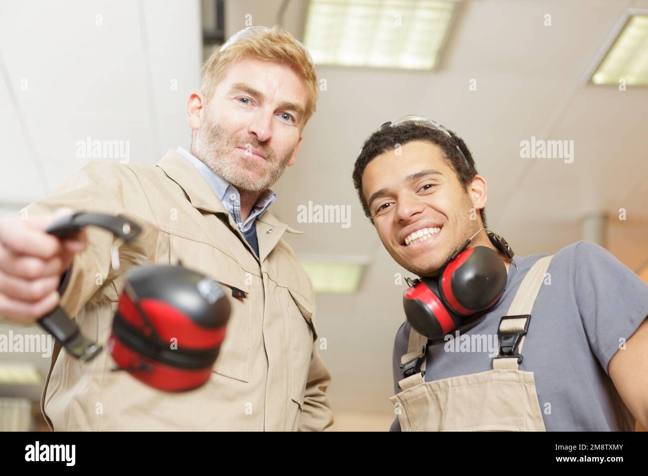 two men in workwear in a carpenters workshop Stock Photo - Alamy