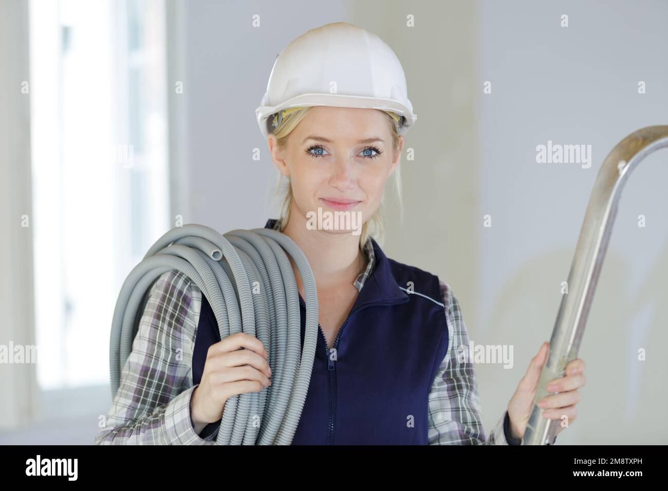 beautiful female electrician holding cable Stock Photo - Alamy