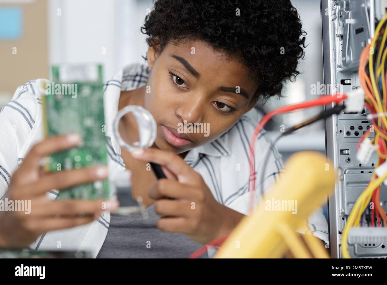 female engineer using solder and magnifying glass Stock Photo - Alamy