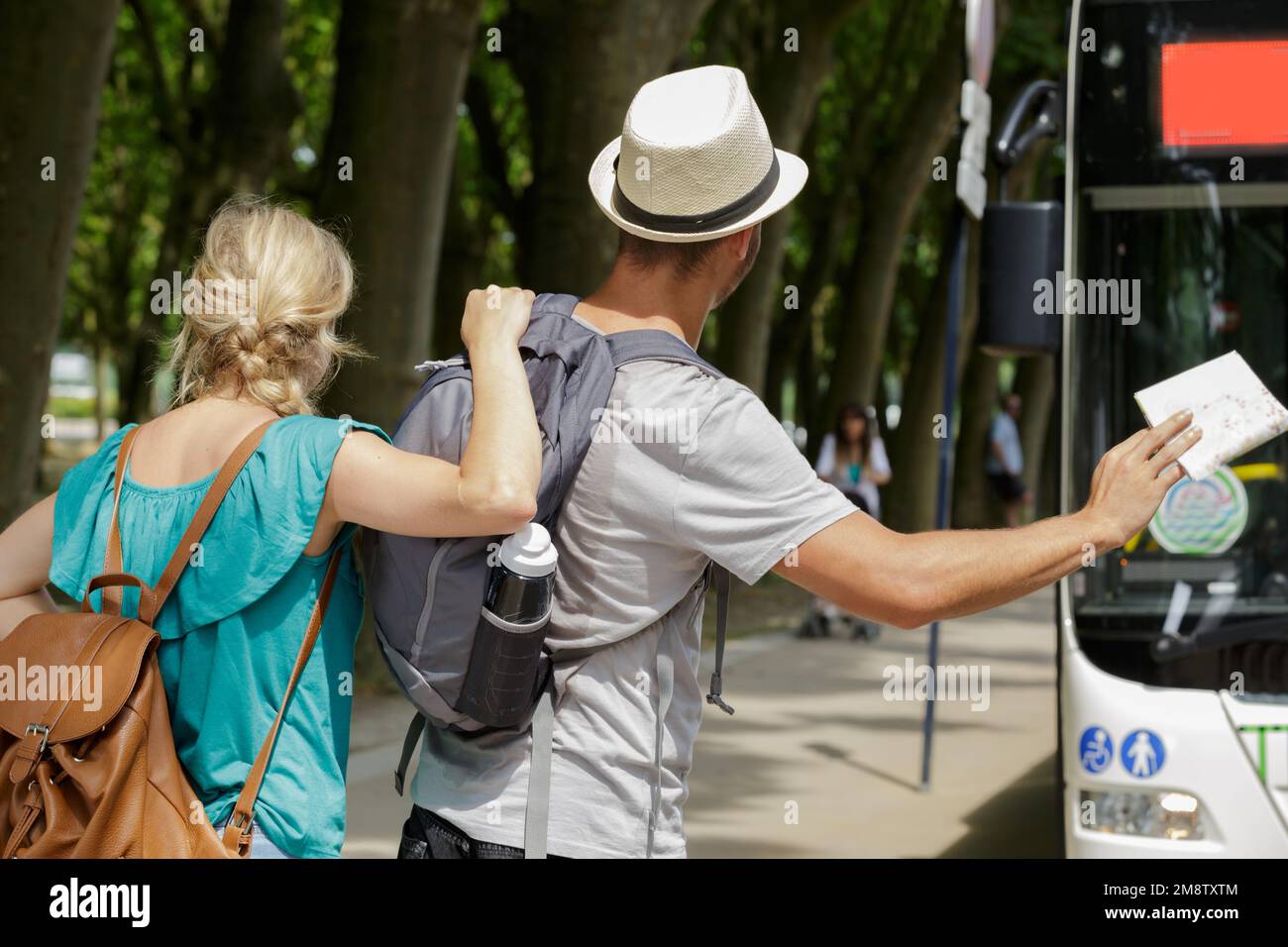 rear view of couple flagging down a bus Stock Photo - Alamy