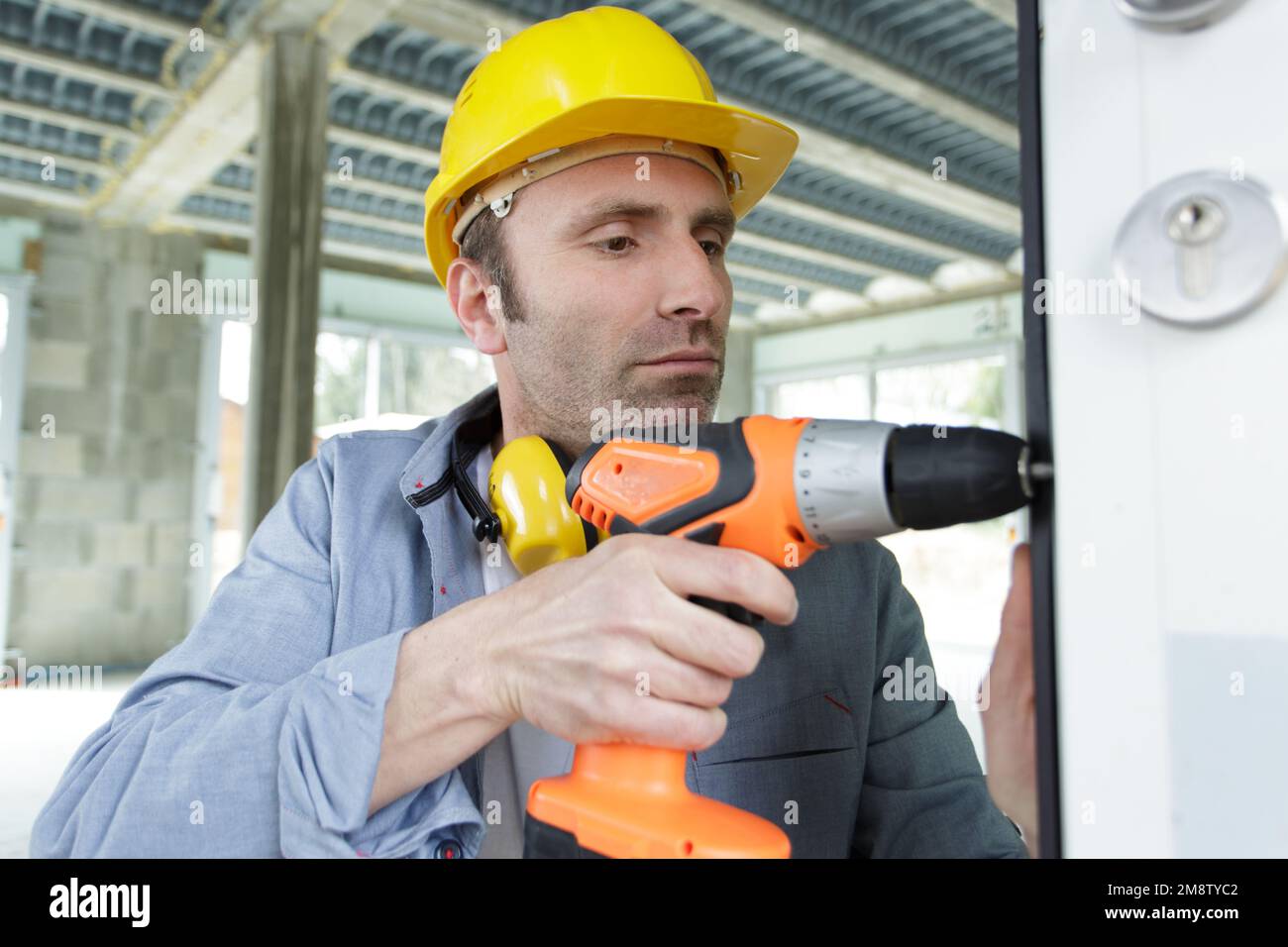 male builder is drilling a wood frame Stock Photo - Alamy
