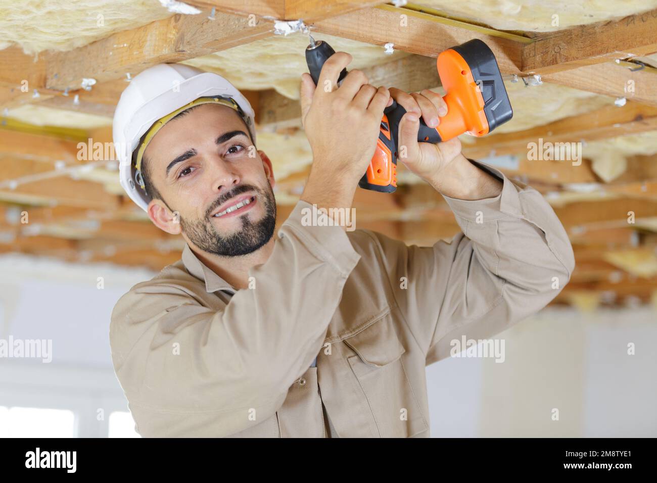 happy builder installing the ceiling Stock Photo - Alamy