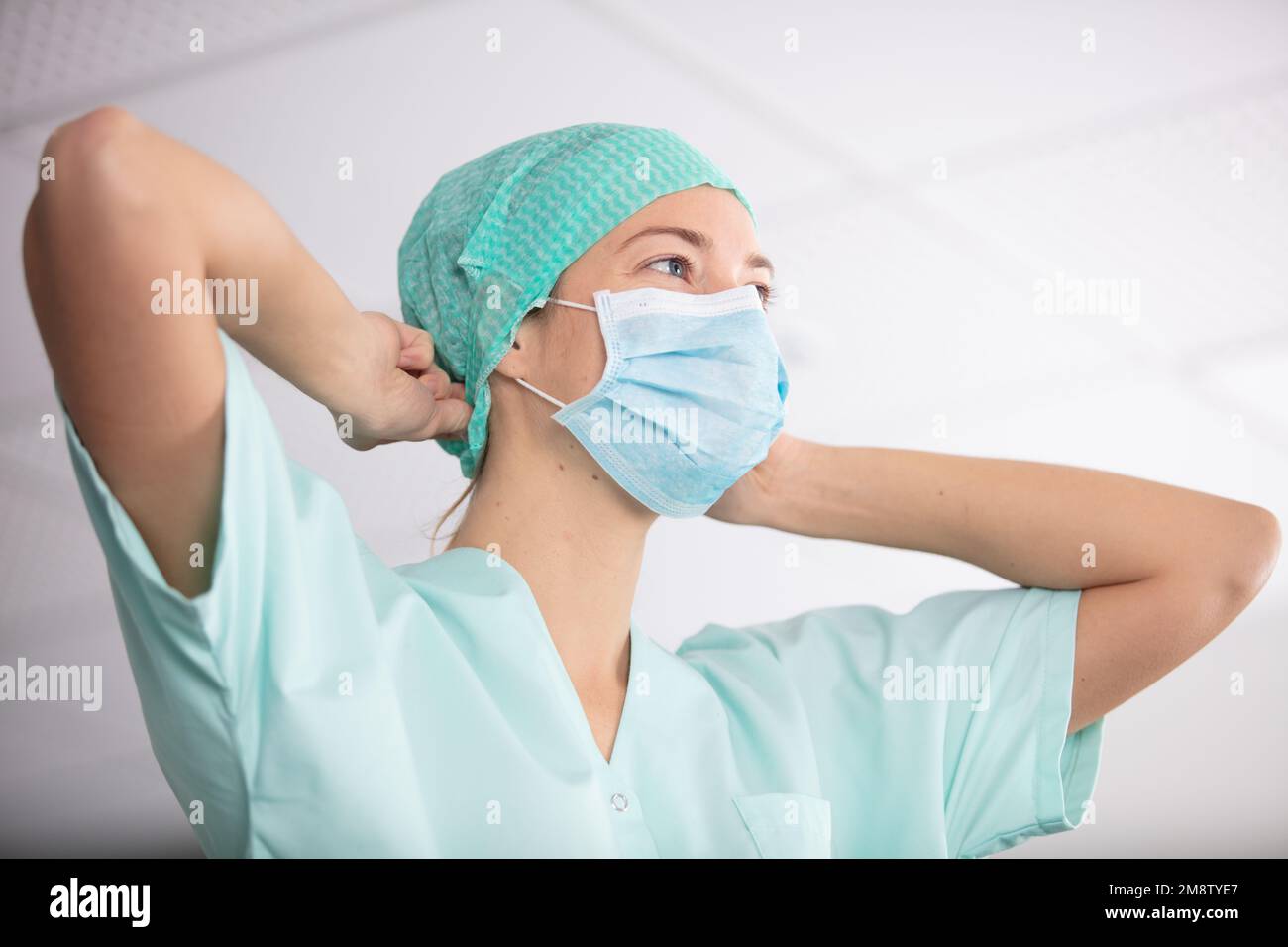 female nurse putting on a mask Stock Photo - Alamy