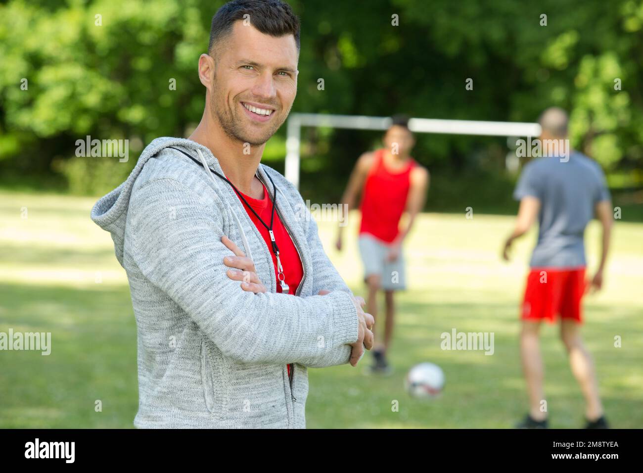 a proud football coach posing Stock Photo - Alamy